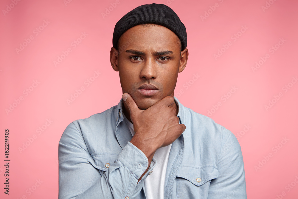 Isolated shot of mixed race dark skinned male has very serious and ...