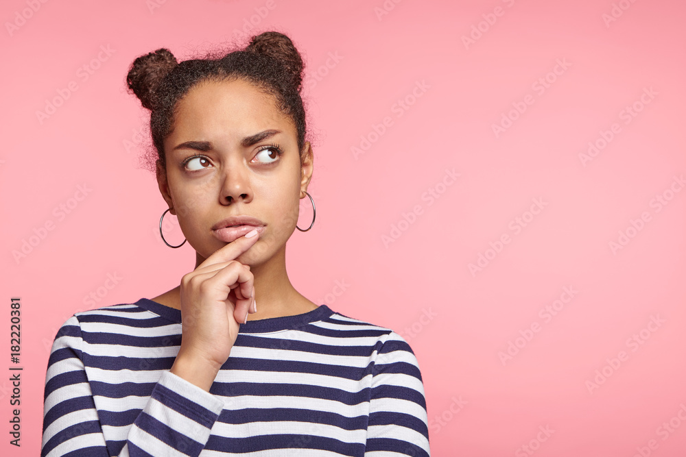 Mixed race female model looks pensively asise, tries to make decision ...
