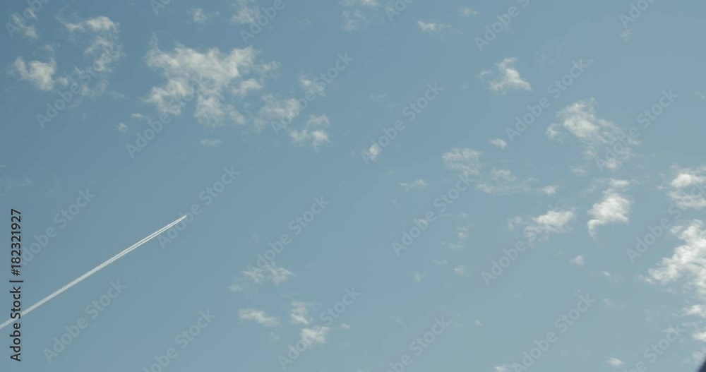 A commercial airliner is flying diagonally left to right of the frame ...