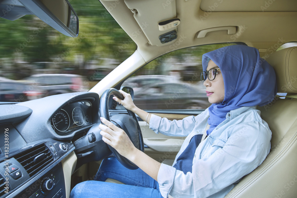 Muslim woman driving a car with fast motion Stock Photo | Adobe Stock