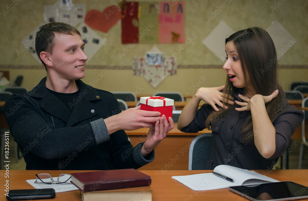 Young man student confesses love to his girl classmate and gives her a ...