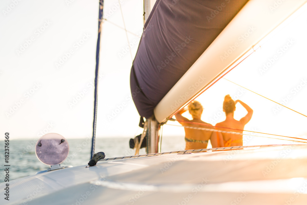 Women in bikini on the sailing boat watching the sea and horizon ...
