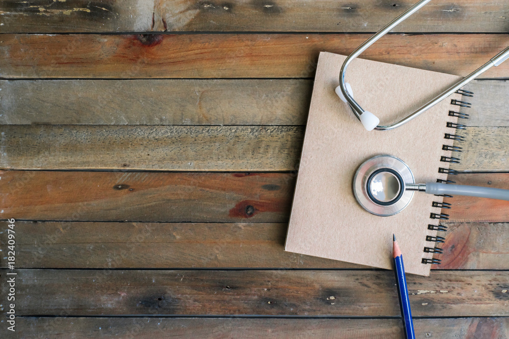 Notepad with stethoscope and pencil on wood board background.using ...