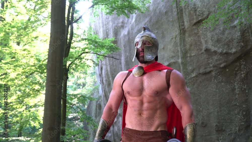 Shot of a muscular medieval soldier in a battledress showing off his ...