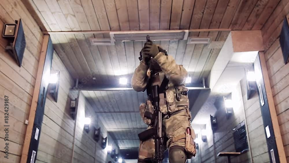 Special forces soldier in full gear goes and shoots a gun at the target ...