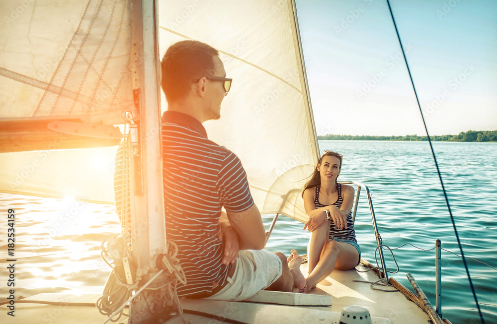Romantic couple in love on sail boat at sunset under sunlight on yacht ...
