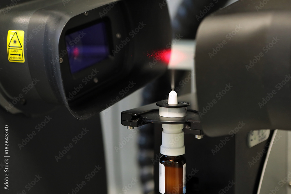 The worker measures the size of the particles and drops of the spray ...