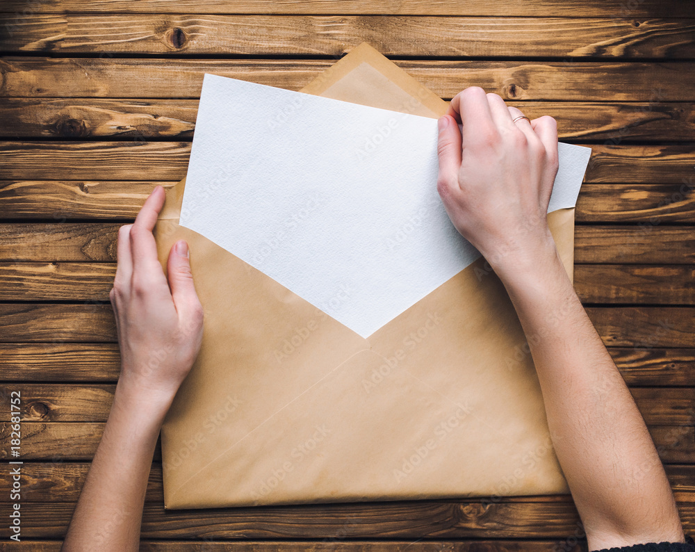 Female hands open a large brown envelope and take out a letter from it ...