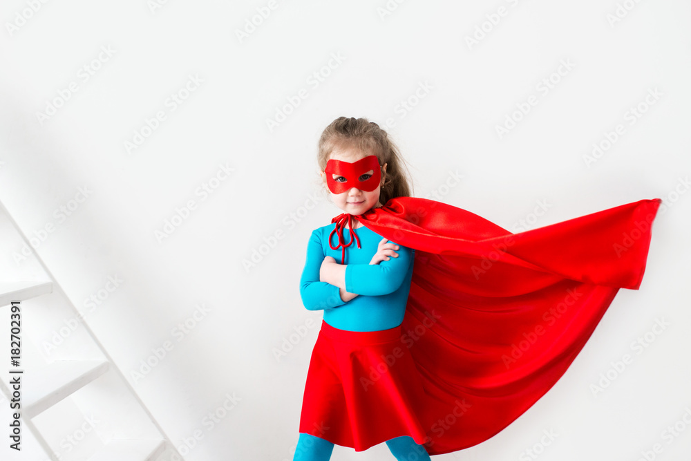 Little girl superhero in a red cloak and mask on white background ...