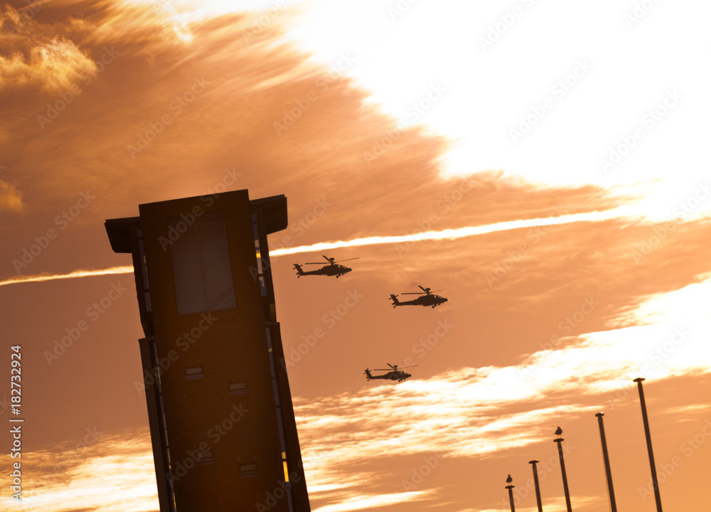 apache helicopters and tower in apocalyptic war scene with orange skies ...
