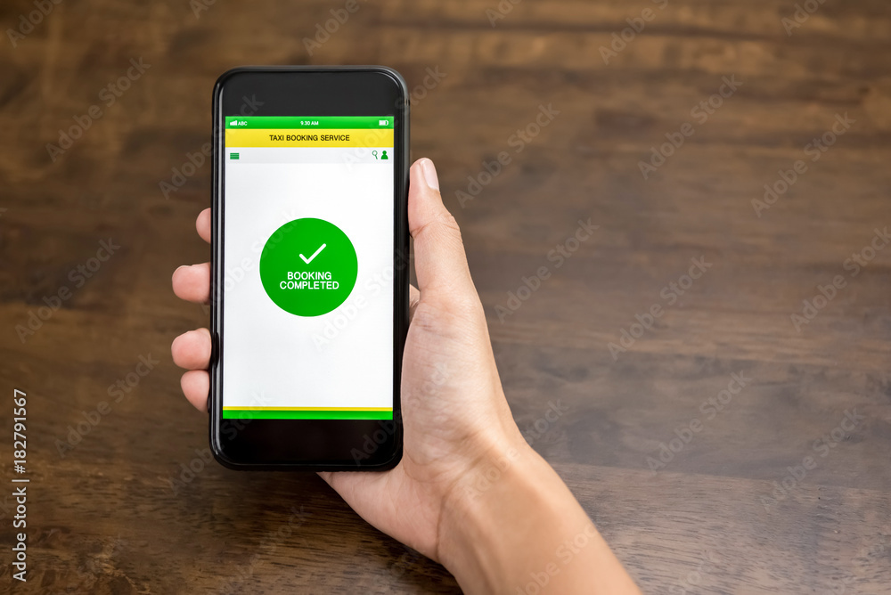 Hand holding smartphone showing confirmation text in taxi reservation ...