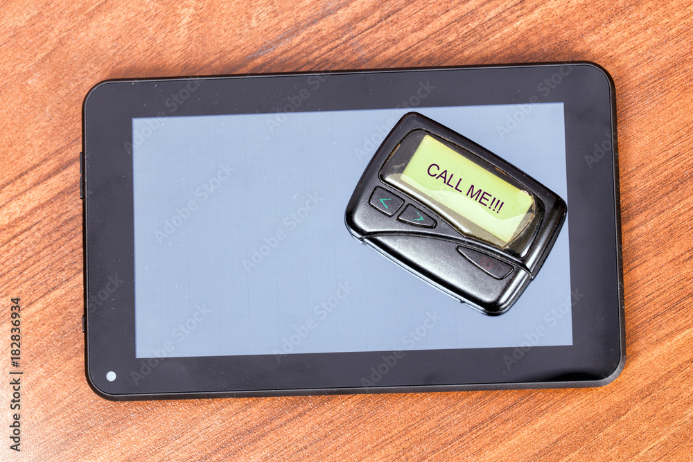 The old pager lies on a modern tablet. The inscription on the pager ...