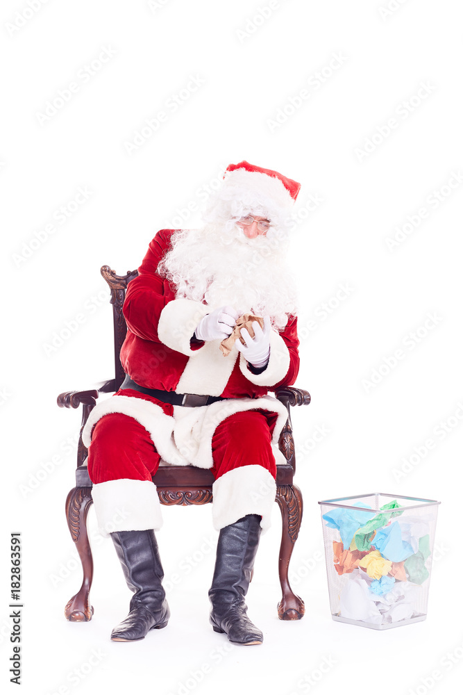 Bad Santa Claus reading letters from kids, crumpling them and throwing ...