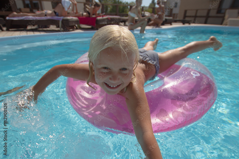 Blonde kid having good time in pool, little girl swimm in sumertimes ...