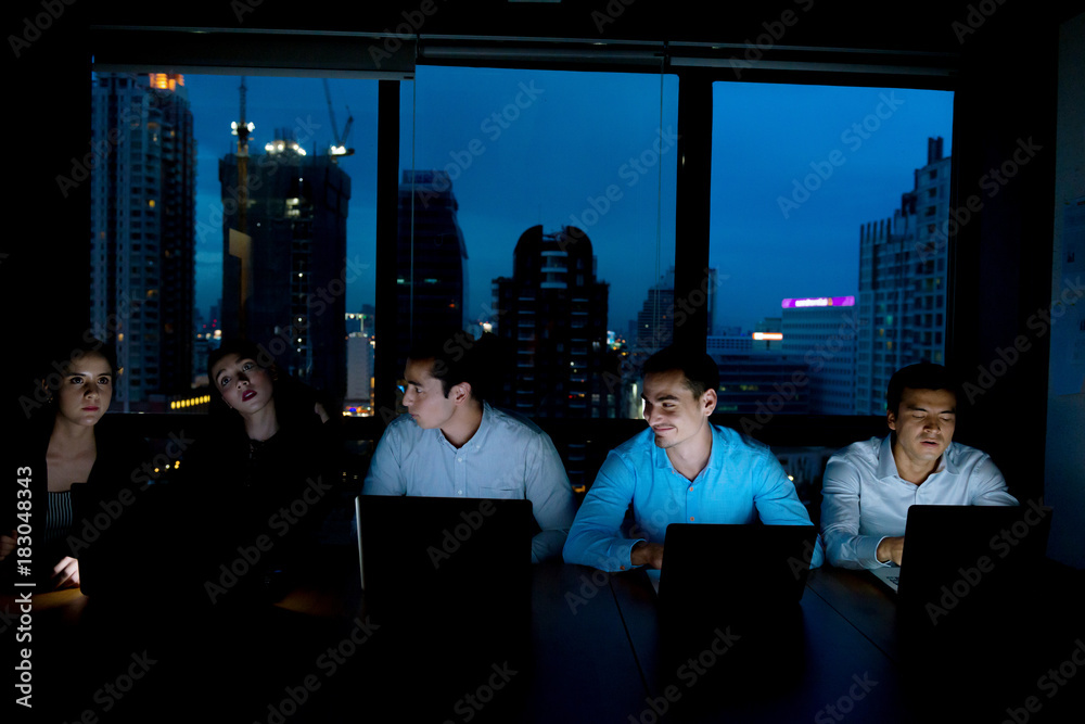 Working overtime concept. Group of young business team working late at ... Working overtime concept. Group of young business team working late at ...