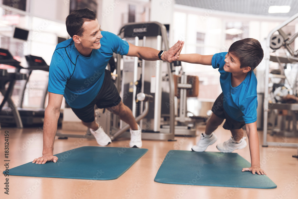 Dad and son in the same clothes in gym. Father and son lead a healthy ...