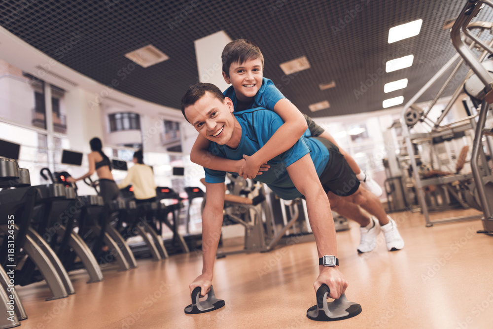 Dad and son in the same clothes in gym. Father and son lead a healthy ...