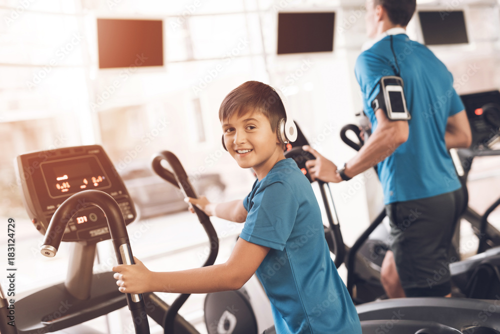 Dad and son in the same clothes in gym. Father and son lead a healthy ...
