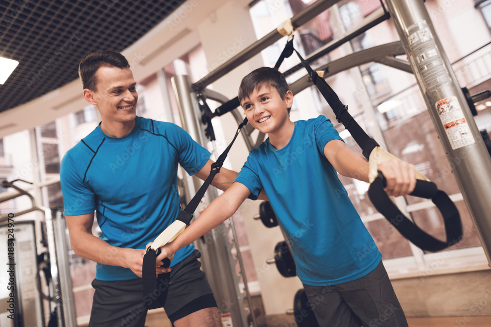 Dad and son in the same clothes in gym. Father and son lead a healthy ...