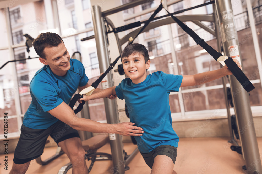 Dad and son in the same clothes in gym. Father and son lead a healthy ...