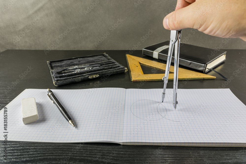 Drawing a circle using a compass in a checkbook. Stock Photo | Adobe Stock
