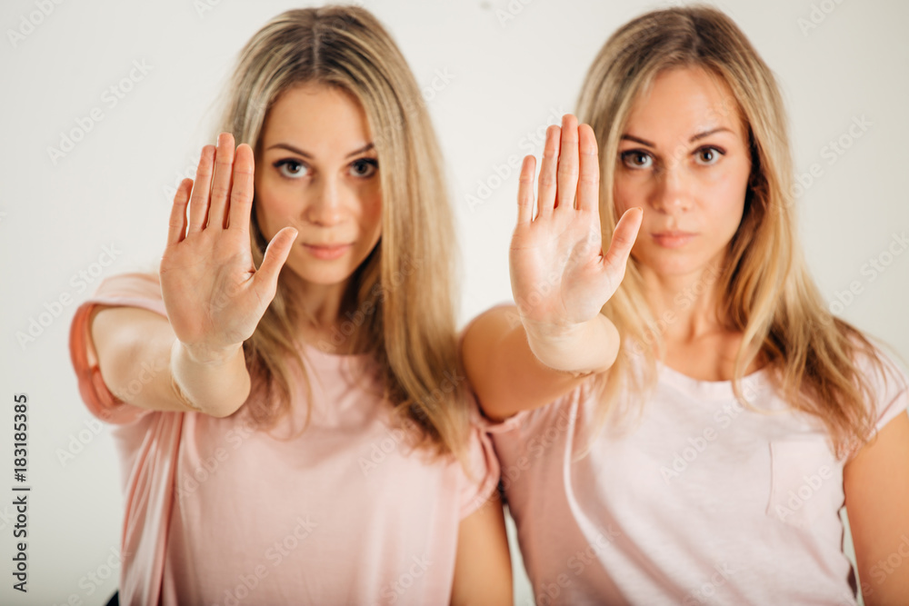 Twin sisters making stop sign over white background. Stock Photo ...