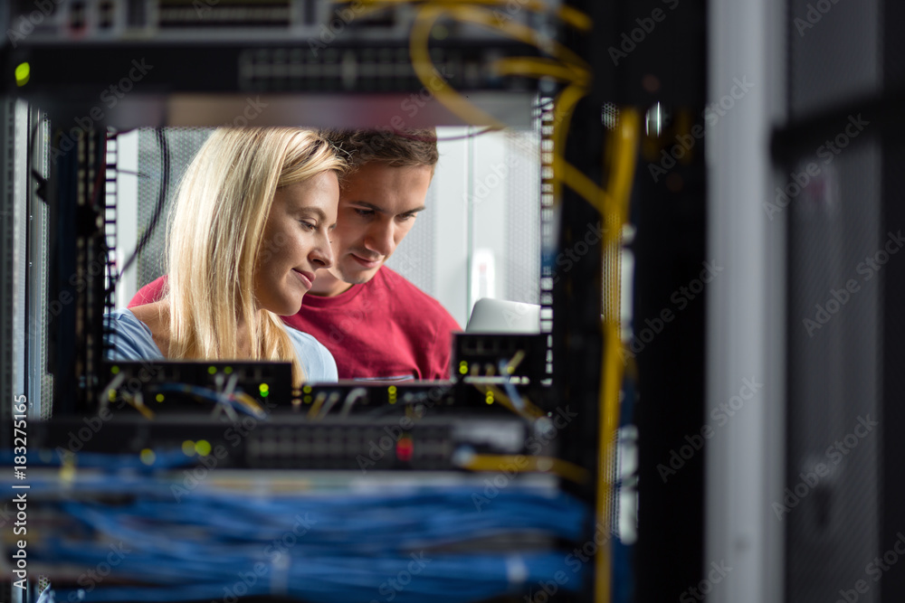 Team of technicians working together on servers at the data centre ...