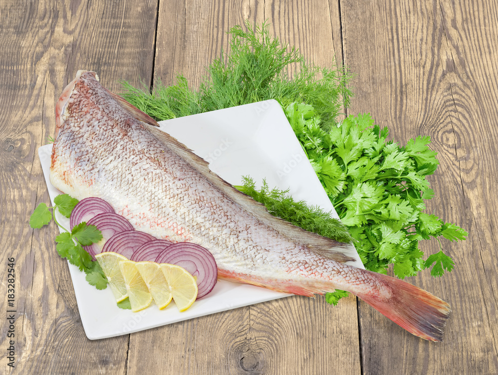 Uncooked red cod, sliced lemon and red onion, herbs Stock Photo | Adobe ...