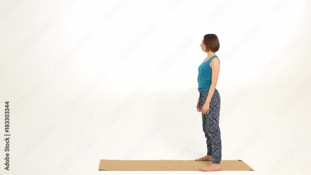 Woman demonstrates stretching exercises on a yoga mat against a white ...