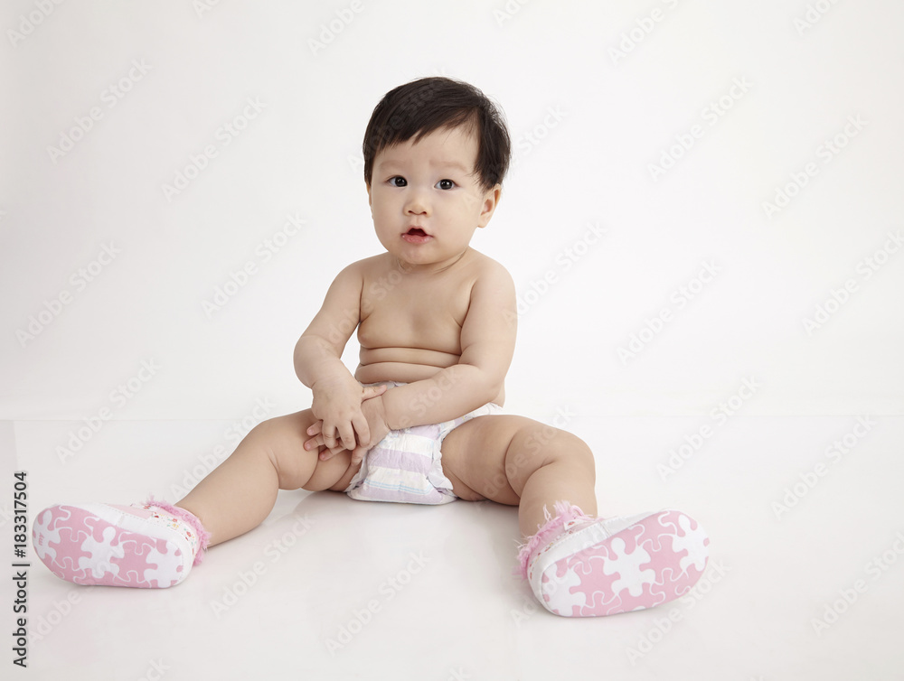 baby in diaper sitting on the floor Stock Photo | Adobe Stock