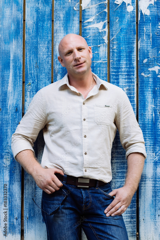 portrait of bald handsome man at natural shirt and jeans, boods. model ...