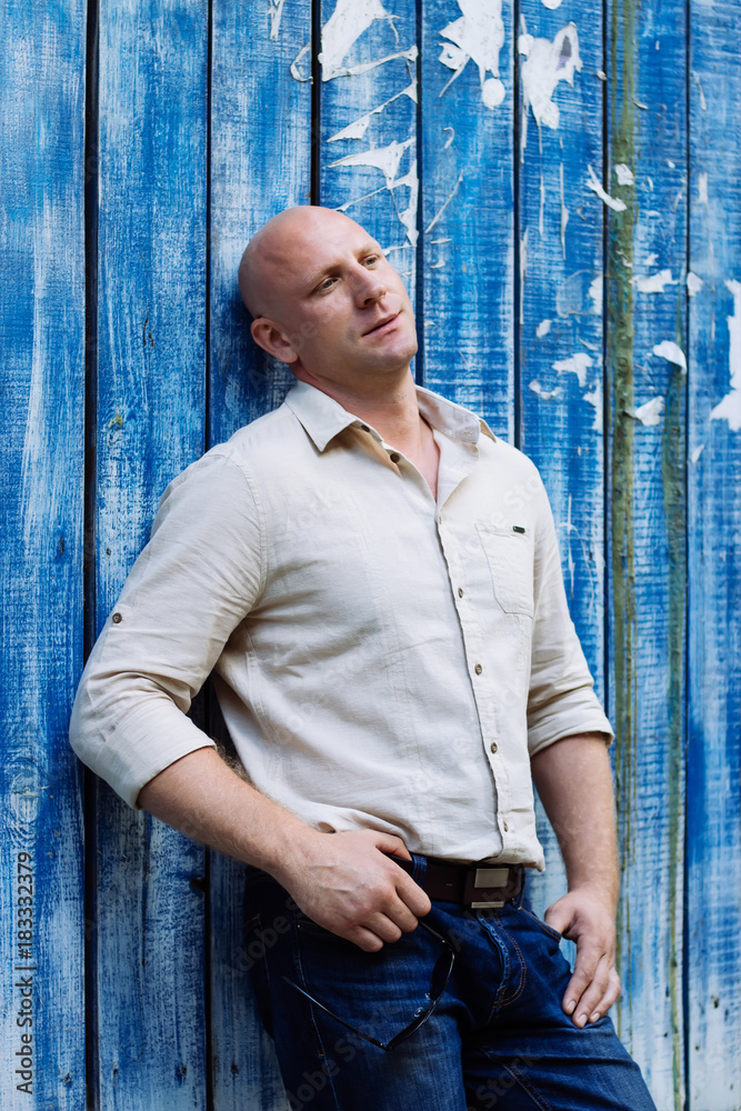 portrait of bald handsome man at natural shirt and jeans, boods. model ...