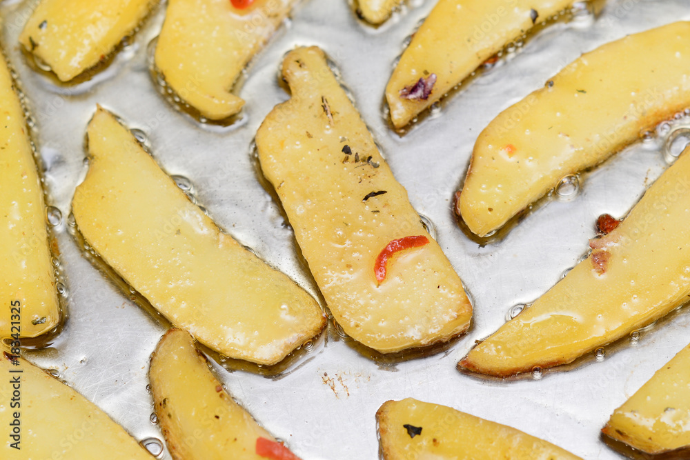 Slices of potato fried on a metal surface in hot oil food background ...