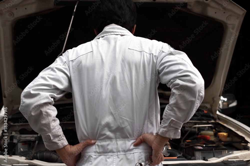Frustrated stressed young mechanic man in white uniform feeling ...
