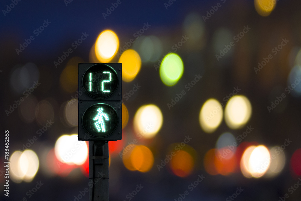 Pedestrian green traffic light at night with the timer on the ...