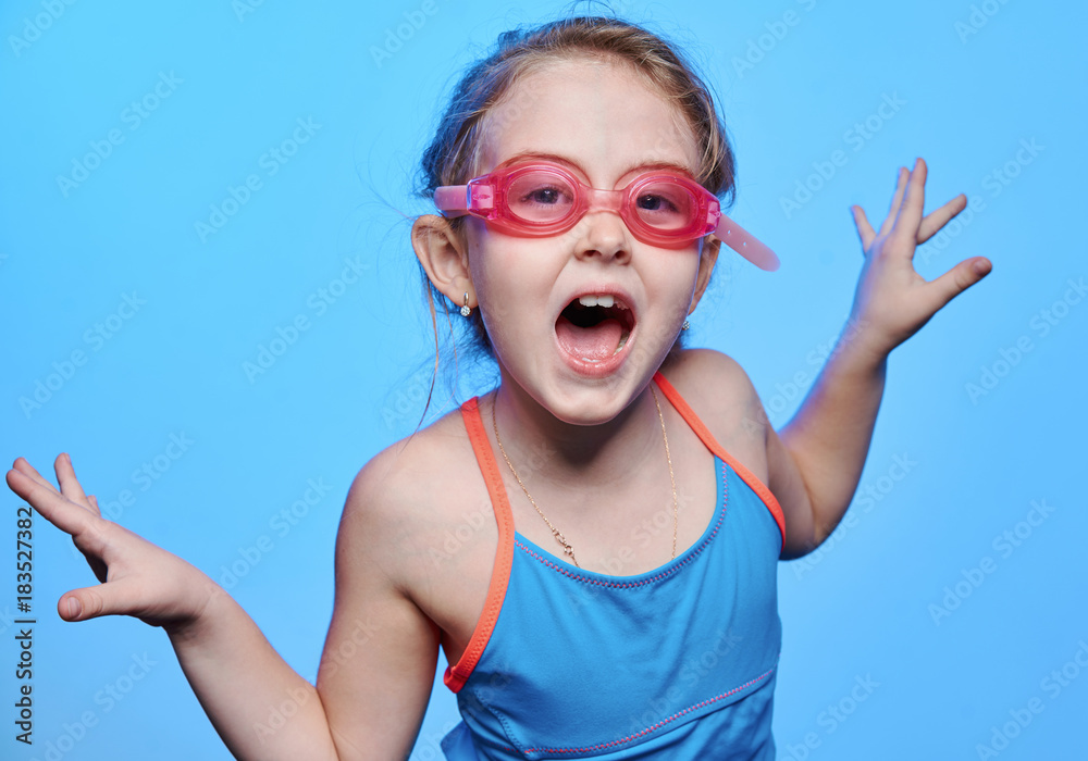 little girl on a blue background in pink swimsuit and glasses for ...