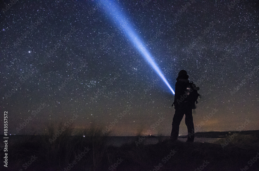 Exploring the night sky with a torch in hand Stock Photo | Adobe Stock