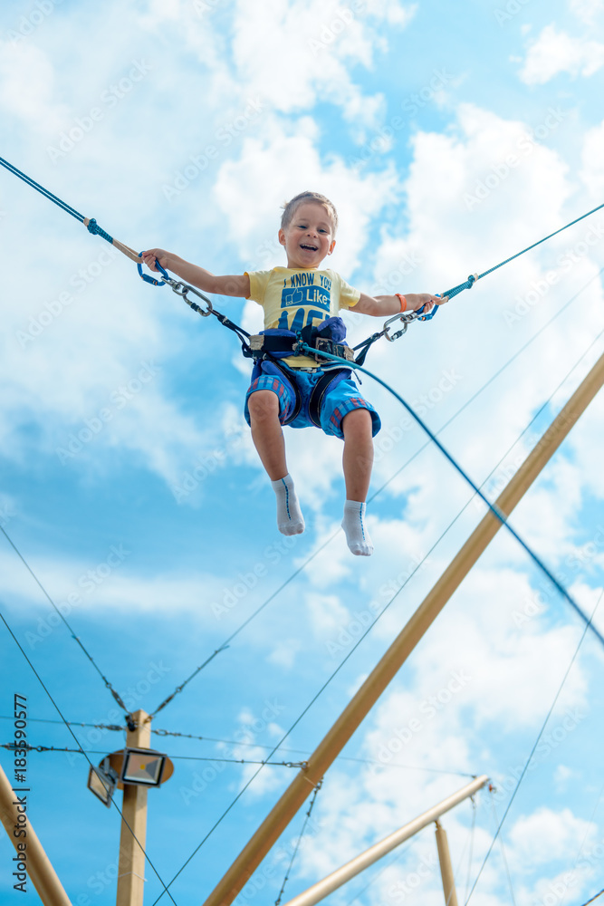Happy boy flying in the air on the trampoline Stock Photo | Adobe Stock