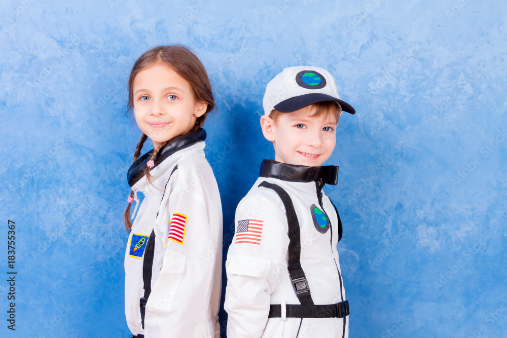 Young children boy and girl playing in astronaut in white astronaut ...