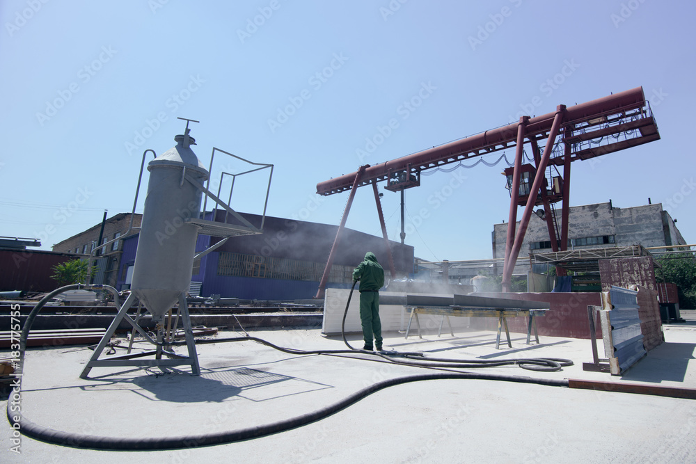 factory for cleaning of metal by sandblasting. a man cleans a metal profile sandblasting Stock ...
