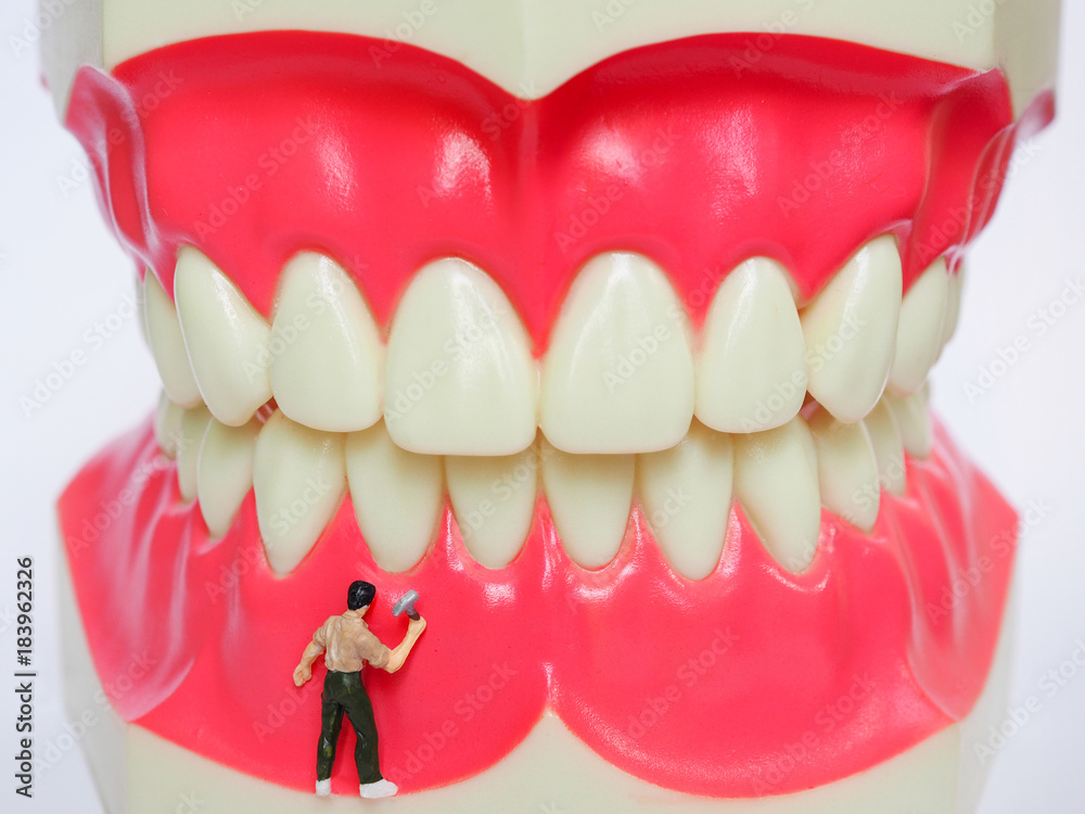 Miniature worker on plastic teeth of removable denture. Dental health ...