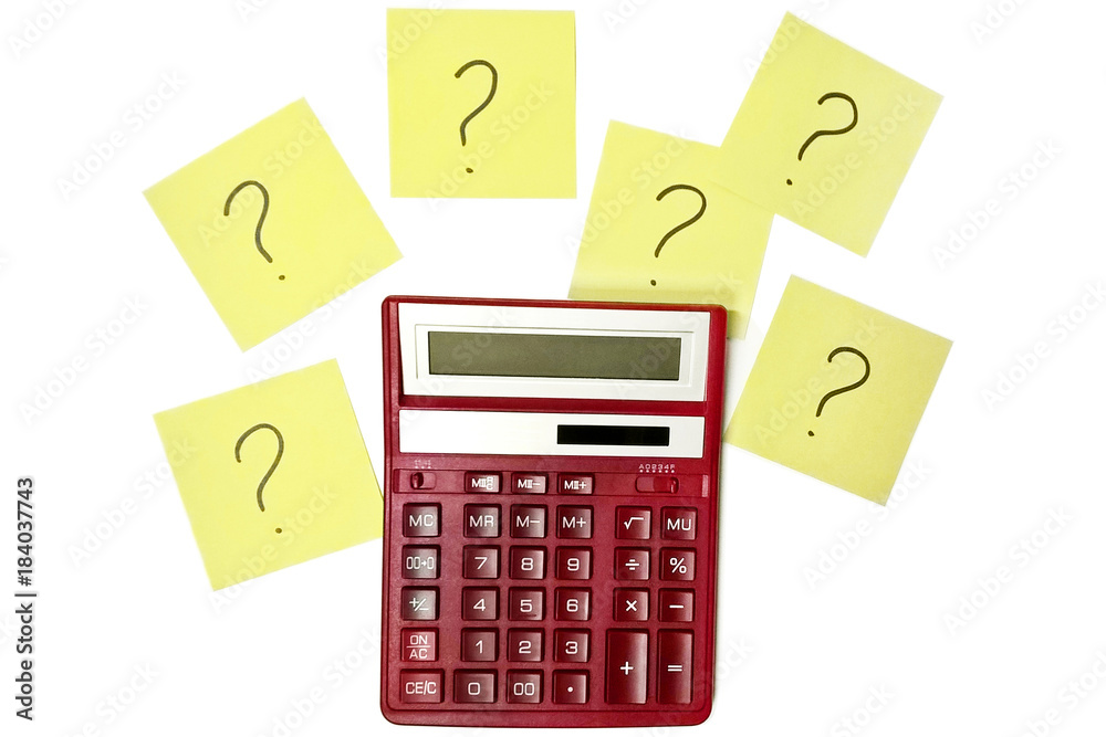 Red electronic calculator and question marks on pieces of paper ...