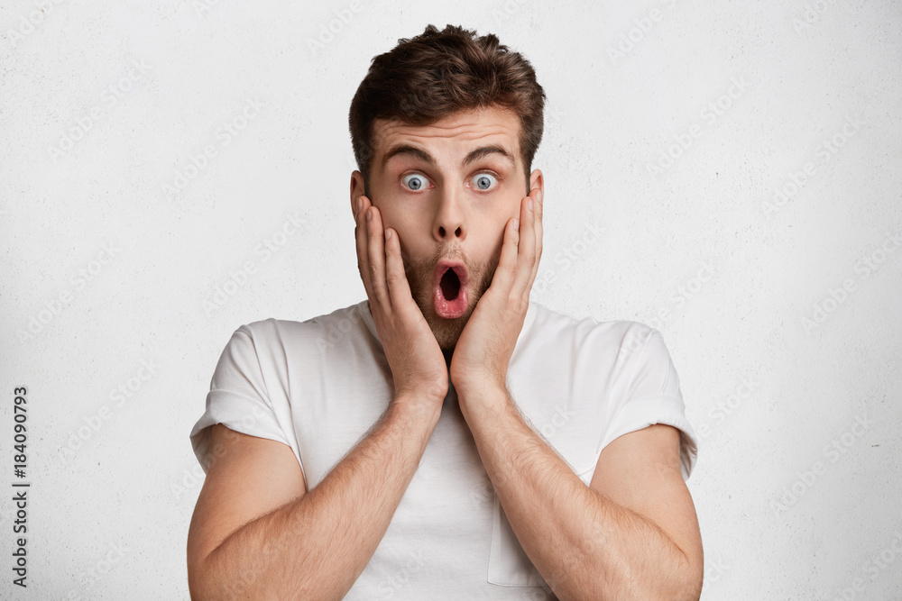 Foto de Portrait of shocked stupefied young male model with trendy ...