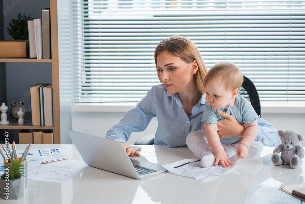 Portrait of serene businesswoman typing in laptop. interested baby ...