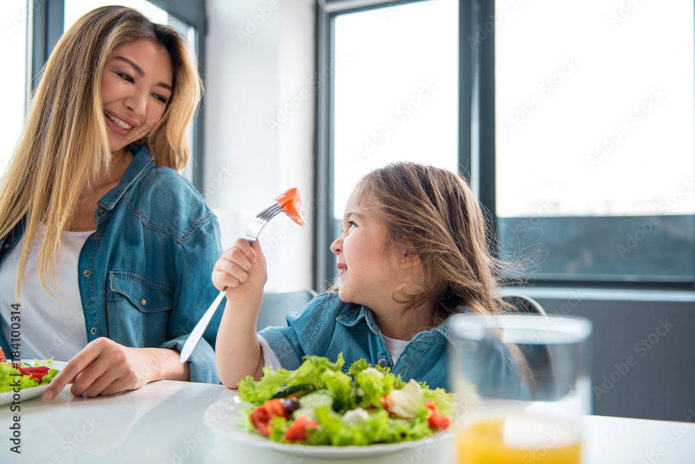 Woman Eating Salad While Laughing