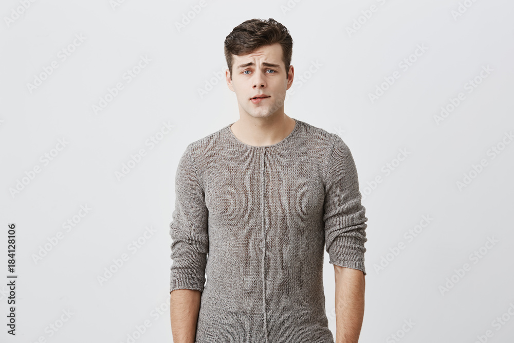 Headshot of puzzled and confused male student dressed casually, looking ...