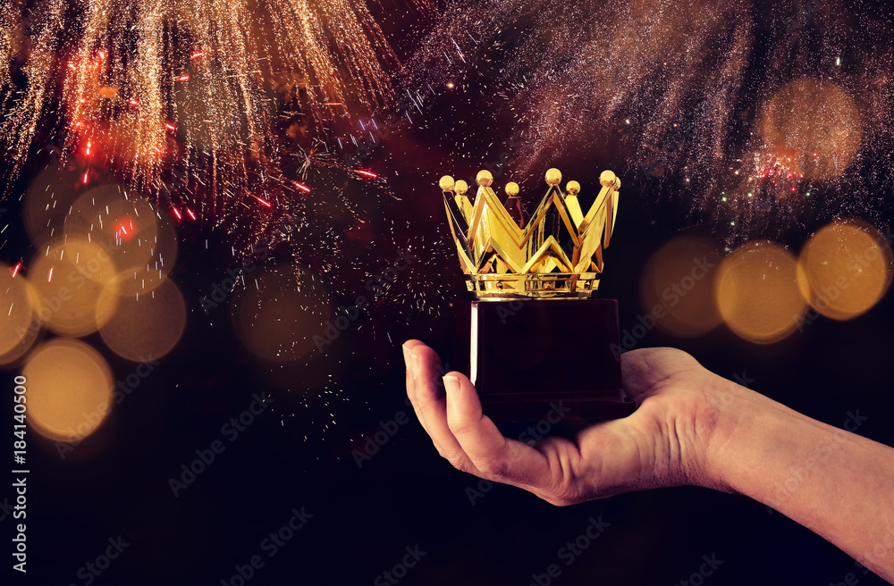 Man's hand holding crown award trophy for show victory or winning first ...