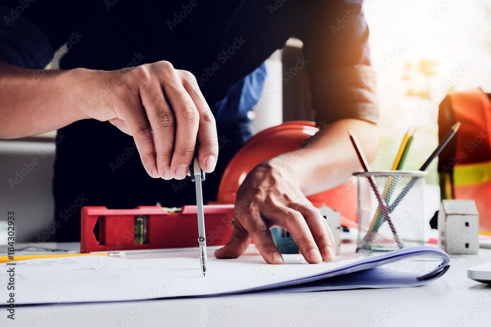 Young engineers using dividers of drawing house building stucture ...