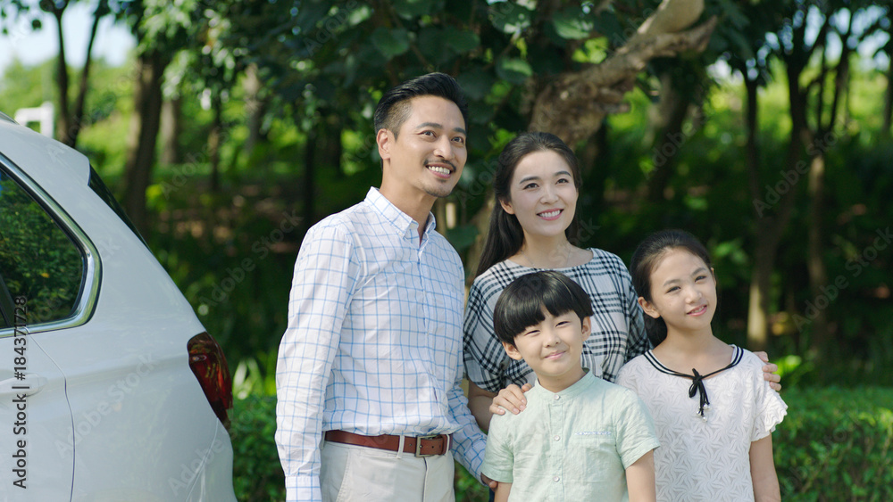 Asian family standing beside car looking forward and smiling Stock ...