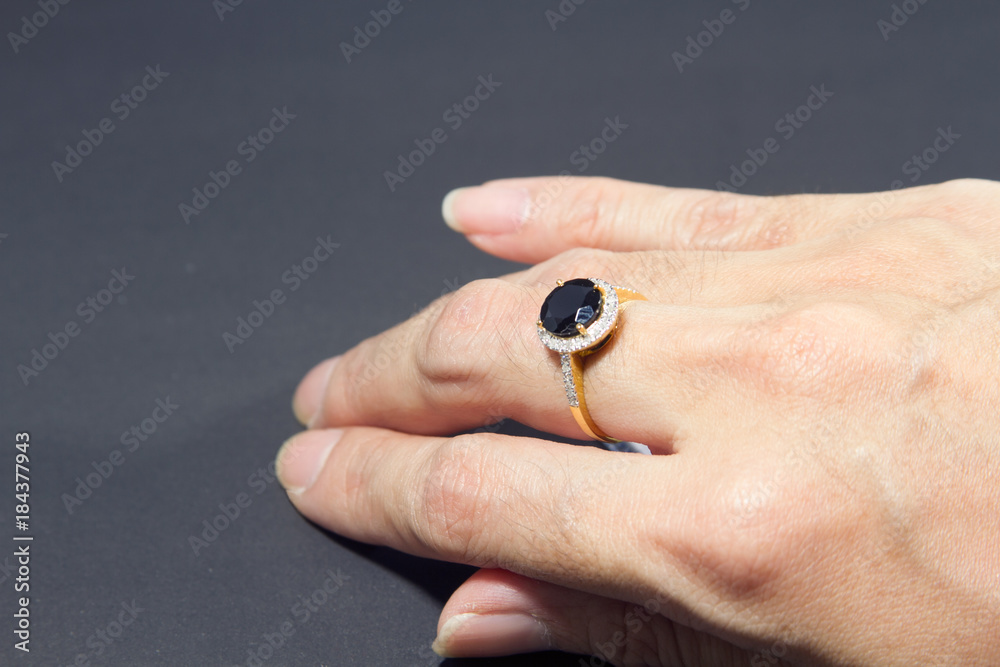 Hand female wears a black diamond ring with middle finger a diamond on ...